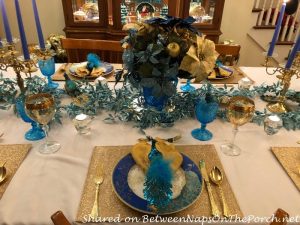 A Celebratory Table Setting in a Beautiful Peacock Theme of Blue and Gold